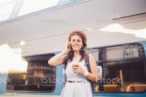 테마 관광 및 여행 젊은 학생 손에 배낭과 컵 커피와 기차 근처 기차역에 서 드레스와 모자에 아름다운 젊은 백인 소녀 스마트폰 기술 사용 계획에 대한 스톡 사진 및 기타