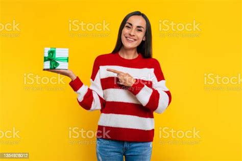 노란 배경에 고립 된 손에 선물 상자와 귀여운 미소 젊은 트렌디 한 여자의 사진을 닫습니다 12월에 대한 스톡 사진 및 기타