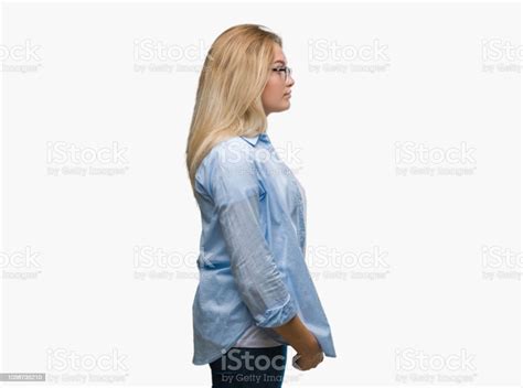 사이드로 보고 격리 된 배경 위에 젊은 백인 비즈니스 여자 입고 안경 긴장 자신감 미소와 자연 스러운 얼굴 프로필 포즈 겨울에