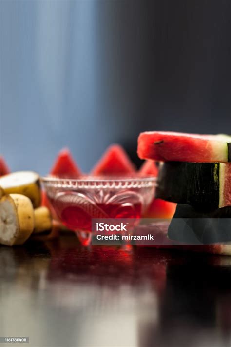 수박 과 바나나로 구성된 삼각형 모양으로 잘라 수박 조각과 함께 유리 그릇에 나무 표면에 수박 얼굴 마스크 또는 얼굴 팩