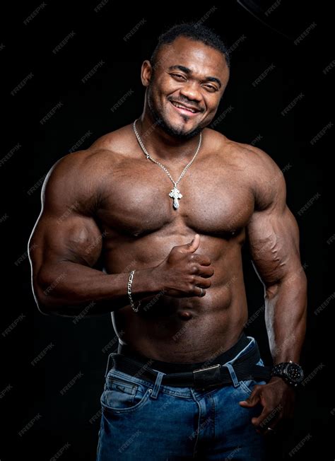 Very Muscular African American Poses To The Camera On Black Background
