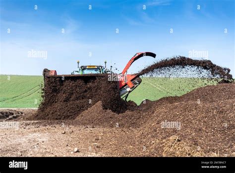 Turning A Manure Heap Over To Make Compost To Spread On Farmland Which