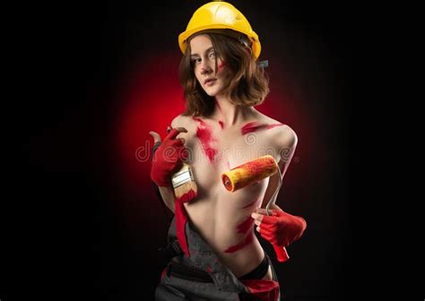 Naked Woman Builder Painter In Overalls And Construction Helmet With A Brush Covered With Red