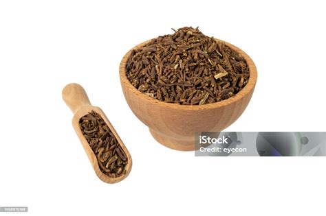 발레리안 허브 뿌리는 나무 그릇에 있고 흰색 배경에 격리된 국자입니다 발레리아나 오피시날리스 진정제로 약초에 사용되며 불면증