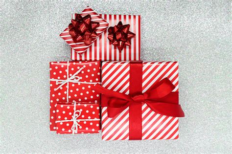 빛나는 은색 배경에 장식 크리스마스 선물 상자와 함께 빨간색 종이에 싸여 다양 한 크기 선물에 대한 스톡 사진 및 기타 이미지