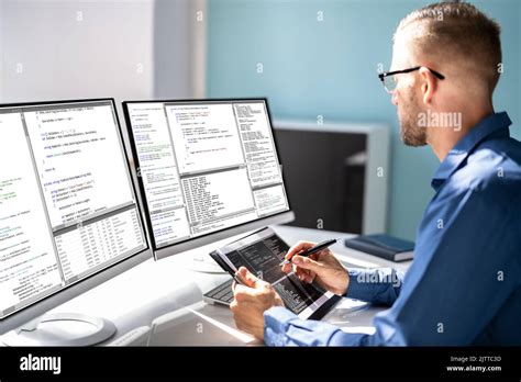 Computer Programmer Writing Program Code On Computer In Office Stock