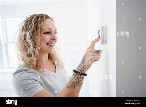 Beautiful Happy Woman Push Button Digital Thermostat At House Stock Photo Alamy