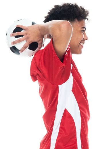 아프리카계 미국인 인종 십대 소년 운동 선수는 축구 유니폼을 입고 축구 공을 들고 축구를하는 흰색 배경 앞에 서 스포츠와 스포츠 공을 사용하여 18 19세에 대한 스톡 사진