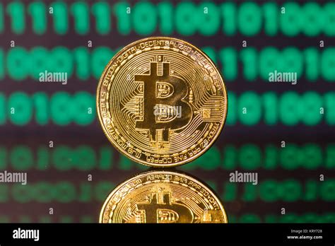 bitcoin symbol in front of a green binary code on a acrylic mirror