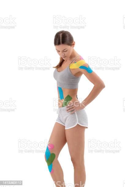 흰색에 고립 된 젊은 운동 여성의 몸에 적용 된 물리 테이프 물리 치료 키네시오 테이핑 운동학 및 회복 치료 개념 근육 서포트