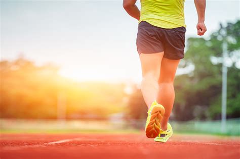 달리기 블록을 사용하여 경주 트랙에서 달리기를 시작합니다 경마장에서 달리는 운동 선수 주자 발 트랙 스타디움에서 조깅하는 젊은 남자 Championship에 대한 스톡 사진