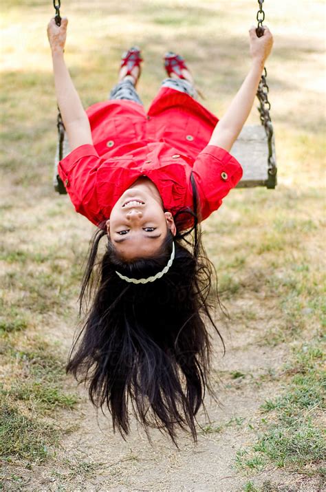 Joyful Girl Upside Down On A Swing By Stocksy Contributor Agha