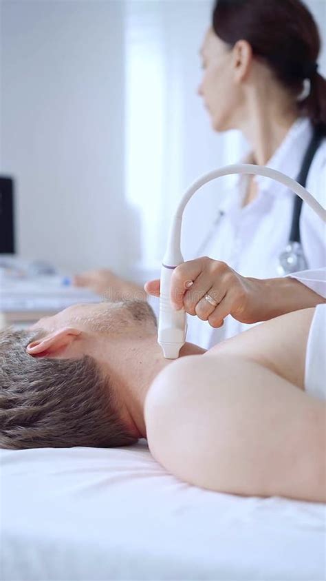 Doctor Woman Performing Neck Ultrasound Exam On Male Patient Medicine