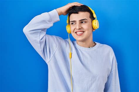 Non Binary Person Listening To Music Using Headphones Smiling Confident