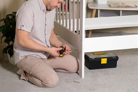 아버지는 아이를 위해 아이들의 침대를 조립하고 남자는 나사를 나무 가구로 비틀어 넣습니다 35 39세에 대한 스톡 사진 및 기타 이미지 Istock