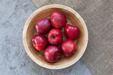 붉은 육즙 사과 나무 상자에 잘 익은 사과 회색 콘크리트 테이블에 나무 접시에 사과 유기농 식품 건강한 음식 개념 맨 위 보기 어두운 돌 테이블에 나무 트레이에 빨간 사과