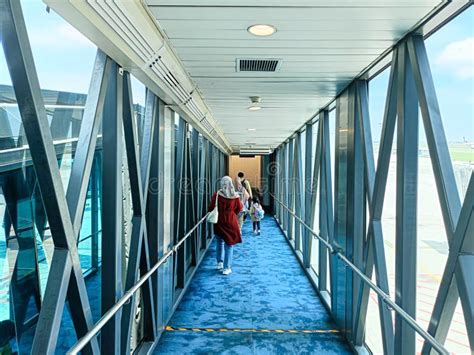 Passengers Walk Onto The Plane Through The Boarding Bridge Editorial