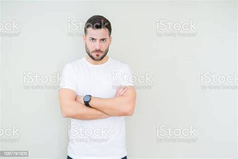 잘생긴 젊은이 격리 된 배경 회의론 및 교차 팔과 얼굴에 긴장 Disapproving 식 캐주얼 티셔츠를 입고 부정적인 사람입니다 T 셔츠에 대한 스톡 사진 및 기타 이미지