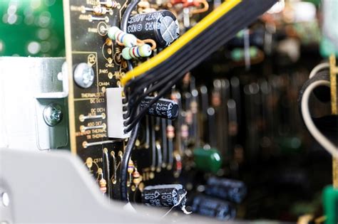 검은색 전자 회로 기판에 검은색 전선 몇 개와 노란색 와이어 하나를 연결하거나 일부 저항기 및 커패시터 구성 요소가 열린 장치에 납땜된 상태로 인쇄하는 P 커넥터의