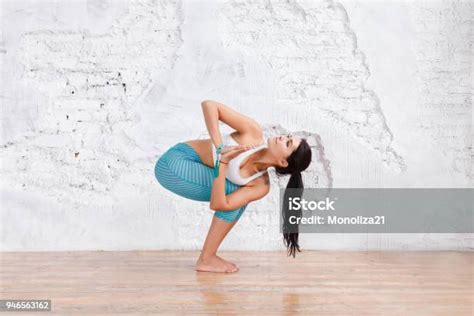 스포티 한 아름 다운 젊은 여자 요가 연습 회전의 자 포즈 Parivritta Utkatasana 파란색 운동복 스튜디오 전체
