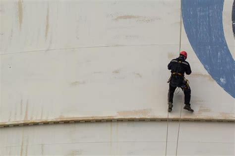 남성 작업자 로프 접근 높이 안전 점검 두께 저장 오일 및 가스 탱크 프리미엄 사진