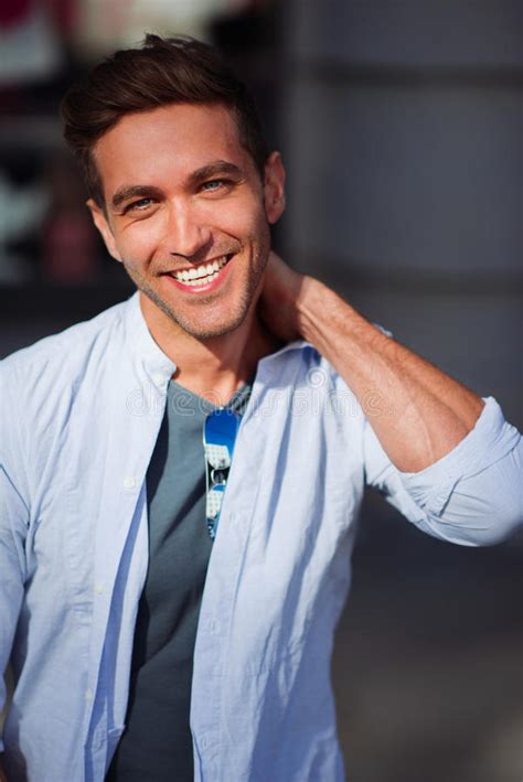 Portrait Of A Laughing Handsome Man Touching His Neck Outside Stock