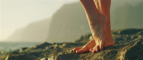 Barefoot Woman Delicately Balancing On A Rock Capturing The Natural