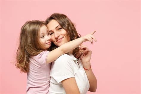 가벼운 옷에 여자는 귀여운 아이 아기 소녀와 재미가 있다 어머니 작은 아이 딸 파스텔 분홍색 벽 배경 스튜디오 초상화에 고립