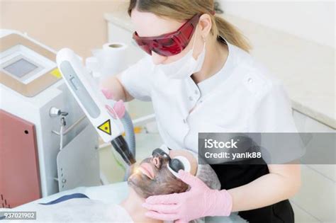 고글에 미용사 여자 게 탄소 미용 레이저의 도움으로 필 링의 절차 탄소 얼굴 필 링 절차입니다 레이저 펄스는 얼굴의 깨끗 한 피부 하드웨어 미용 치료입니다 짧을수록 피부를