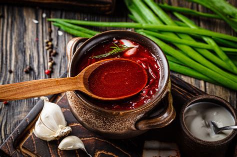 우크라이나어 요리 사워 크림과 우크라이나 베이컨을 곁들인 진흙 냄비에 빨간 수프 보르쉬 나무 테이블에 레스토랑에서 요리를 제공