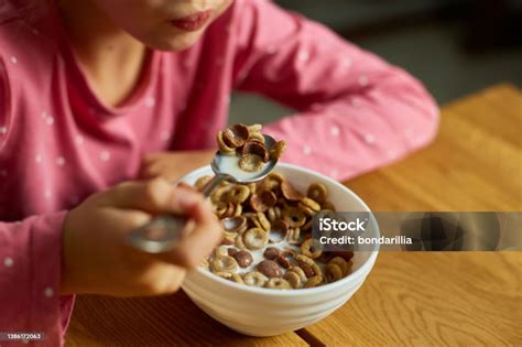 닫기 귀여운 어린 소녀는 식욕과 함께 아침 아침 식사를 위해 우유와 시리얼을 먹는 즐길 수 8 9 살에 대한 스톡 사진 및 기타