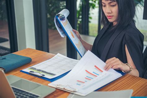 스마트 폰을 사용하는 비즈니스 여성 사무실 책상에 노트북 여성 프리랜서 독서 재무 그래프 차트 마케팅 데이터를 분석 계획 사무실 회사 비즈니스 정보에서 일하는 젊은 여성의