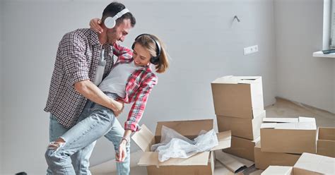 기쁜 잘생긴 낭만적인 남자와 그의 아내는 무선 헤드폰을 입고 골판지 상자 사이에서 탱고 춤을 추고 있다 사진 Unsplash의 판지 이미지