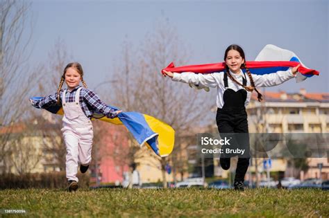 공원에서 행복 실행 우크라이나어와 러시아어 플래그와 아름다운 어린 소녀 우크라이나어와 러시아 사람 사이의 평화의 개념 2명에 대한 스톡 사진 및 기타 이미지 Istock
