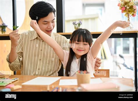 Happy And Cheerful Young Asian Girl Raises Her Hands After Finished