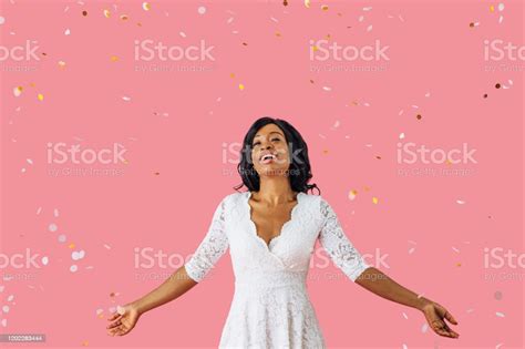 흰색 드레스와 검은 머리를 입은 행복한 젊은 여성의 초상화가 눈을 감고 웃으면서 색종이가 떨어지는 팔로 멋진 삶을 축하합니다 검은색에 대한 스톡 사진 및 기타 이미지