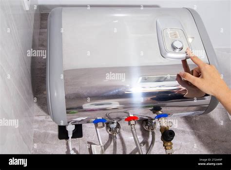 The Girl Regulates The Temperature Of Water Heating In The Boiler In The Bathroom When Hot Water