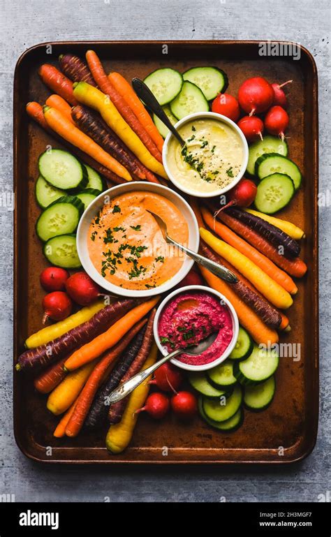 Tray Of Different Flavoured Hummus And Raw Vegetables For Dipping Stock