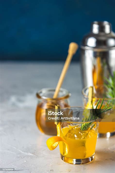 로즈마리 심플 시럽을 곁들인 허니 버번 칵테일 2잔 또는 오렌지와 로즈마리 장식 오렌지 껍질 꿀 항아리 바텐더 도구가 있는 수제