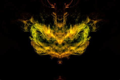 검은 고립 된 배경에 날개와 머리 얼굴과 눈의 모양에 공포의 형태로 다른 녹색 노란색 오렌지와 붉은 색의 연기 신비한 상징의 영혼과 유령 0명에 대한 스톡 사진 및 기타