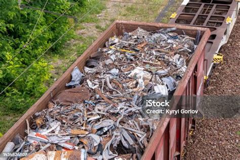 공장 재활용을 위한 오래된 녹슨 검은색 금속 스크랩 쓰레기로 가득 찬 철도 화물 열차 마차의 위 전망 철강 폐기물 수집 폐기