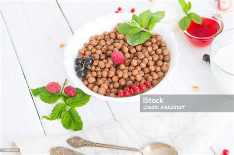 소박한 나무 테이블에 우유와 그릇에 시리얼 초콜릿 공 딸기 라즈베리 검은 건포도와 붉은 건포도와 건강 하고 맛있는 아침 식사 초콜릿 공 0명에 대한 스톡 사진 및 기타