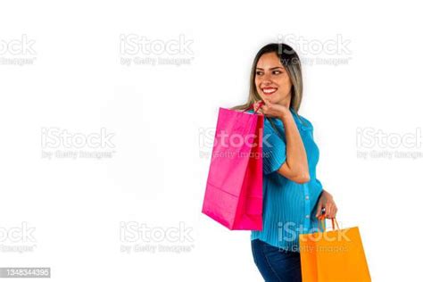 행복한 표정과 다채로운 쇼핑백을 양손에 들고 빈 공간을 들여다보는 아름다운 젊은 여성 공간을 복사합니다 흰색 배경입니다 20 29세에 대한 스톡 사진 및 기타 이미지