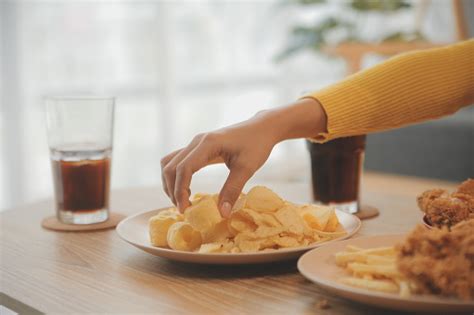 뚱뚱한 여자는 피자 한 조각을 물고 과체중 여성은 패스트 푸드를 먹고 아시아 여자는 배고프다 건강에 좋지 않은 음식에 대한 스톡