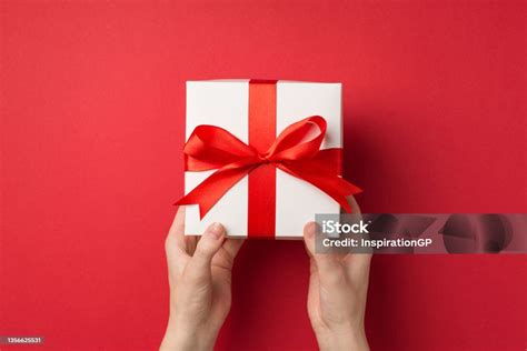 고립된 빨간 배경에 빨간 실크 리본 리본리본이 달린 커다란 흰색 선물상자를 주는 여성의 손 1인상 사진 인간 손에 대한 스톡 사진 및 기타 이미지 Istock