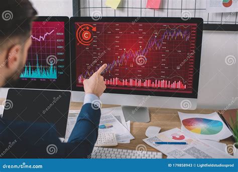 View Of Data Analyst Pointing On Charts On Computer Monitor Near Laptop