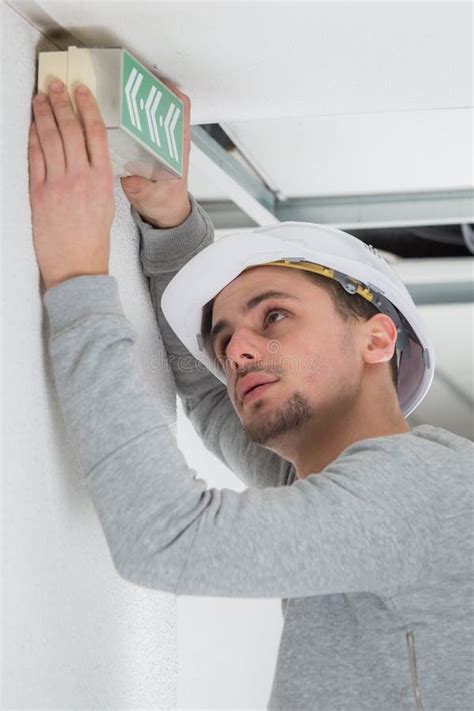 Man Fitting Directional Exit Sign To Wall Stock Photo Image Of Exit Show