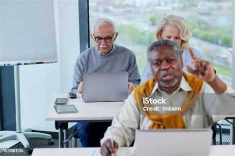 노인들은 교실에 앉아서 노트북으로 프로젝트에 대해 이야기하고 전경의 다문화 고등학생이 질문을합니다 노인에 대한 스톡 사진 및 기타 이미지 Istock