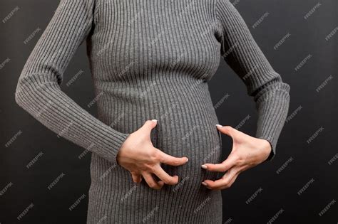 Premium Photo | Pregnant woman scratching her belly on colored background