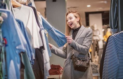 Удивленная молодая женщина покупающая товары в бутике Стоковое Фото изображение насчитывающей